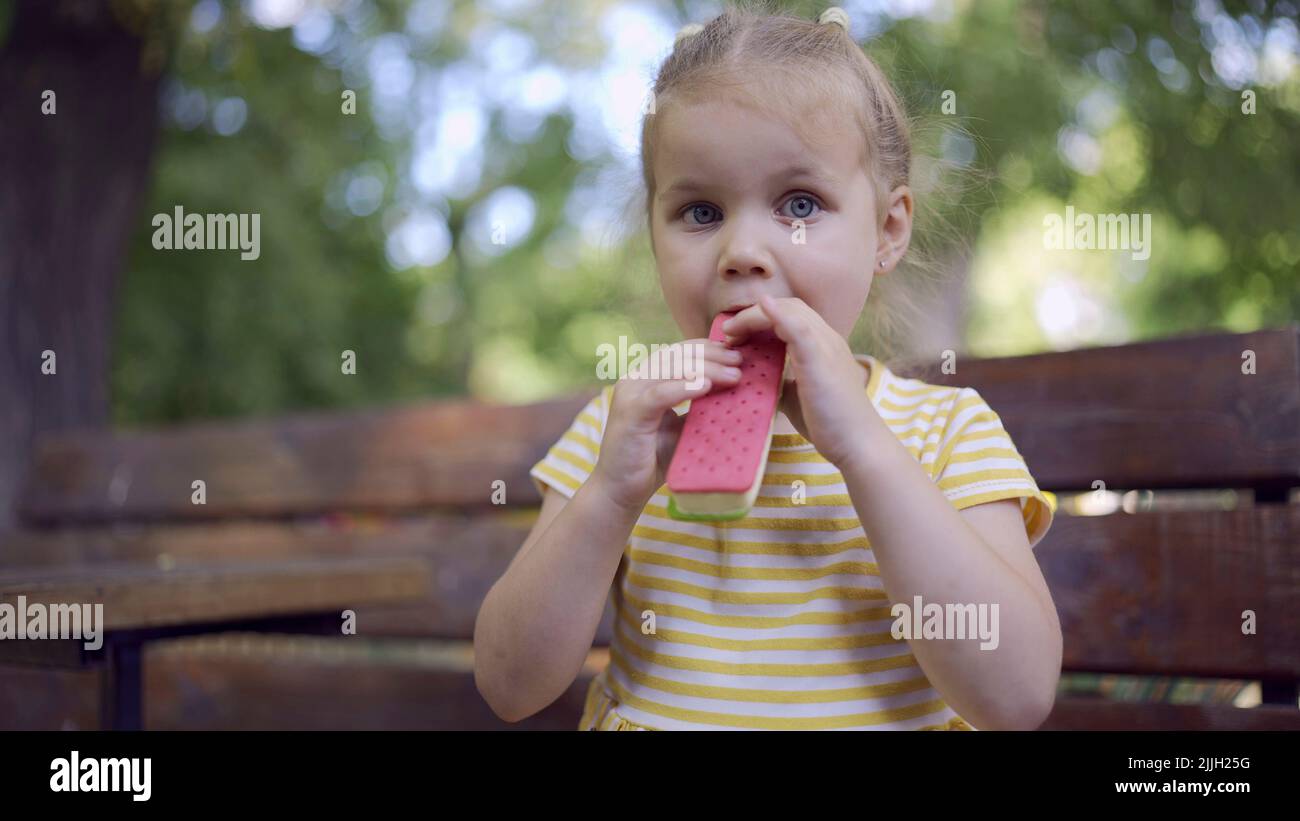 Closeup of cute little girl eats ice cream. Close-up of child girl ...
