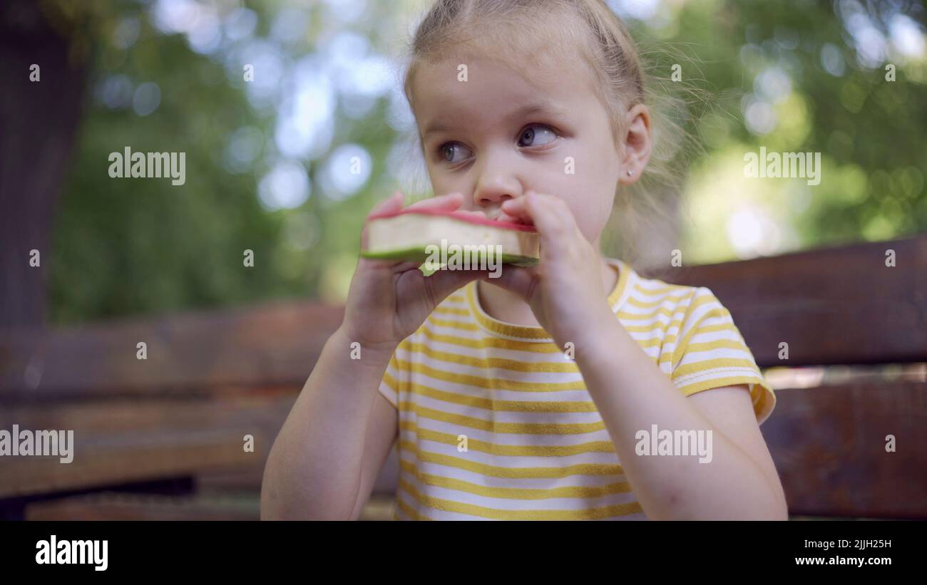 Closeup of cute little girl eats ice cream. Close-up of child girl ...