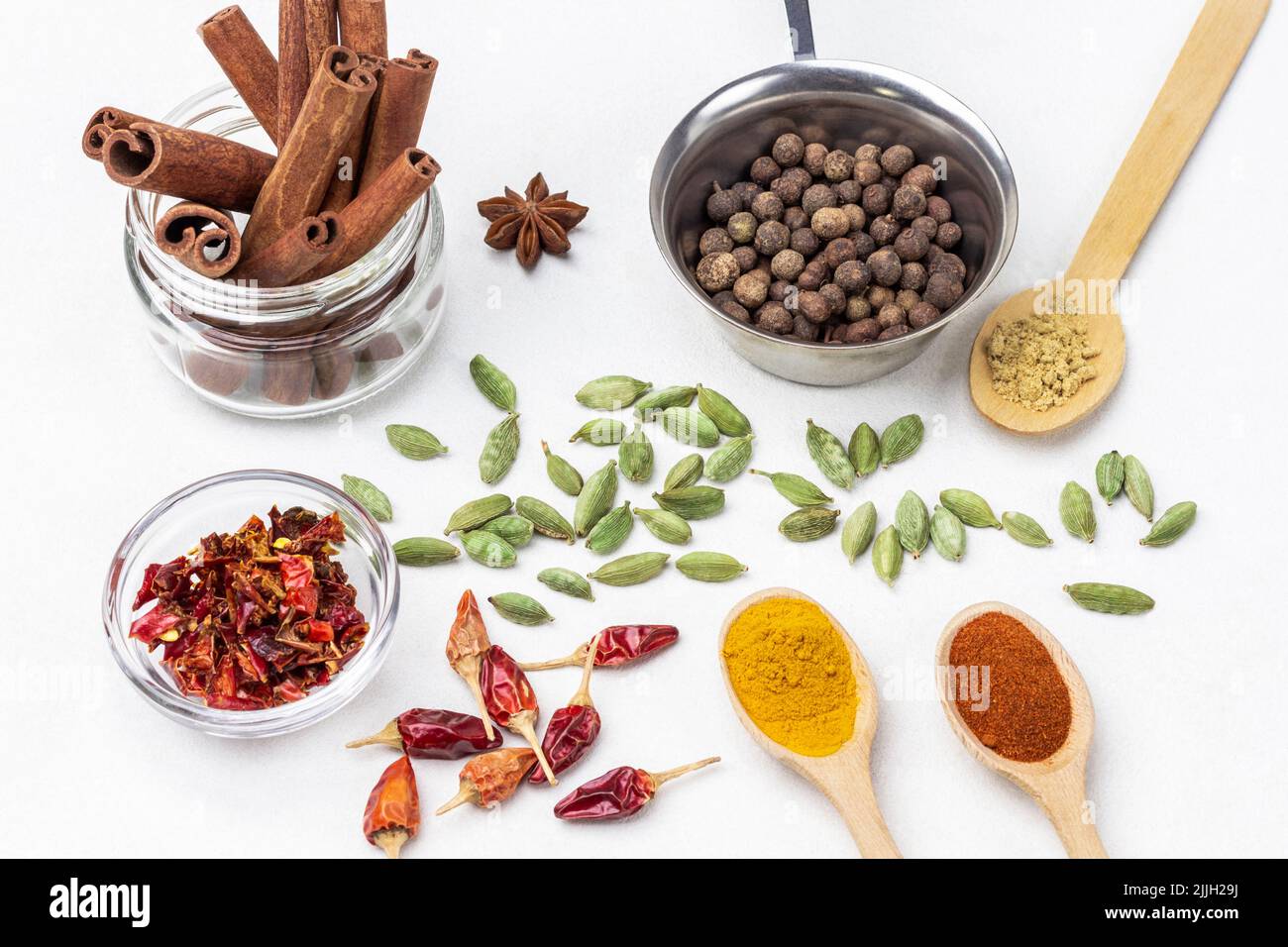 Allspice in metal bowl and cinnamon sticks in jar. Ground spices ...