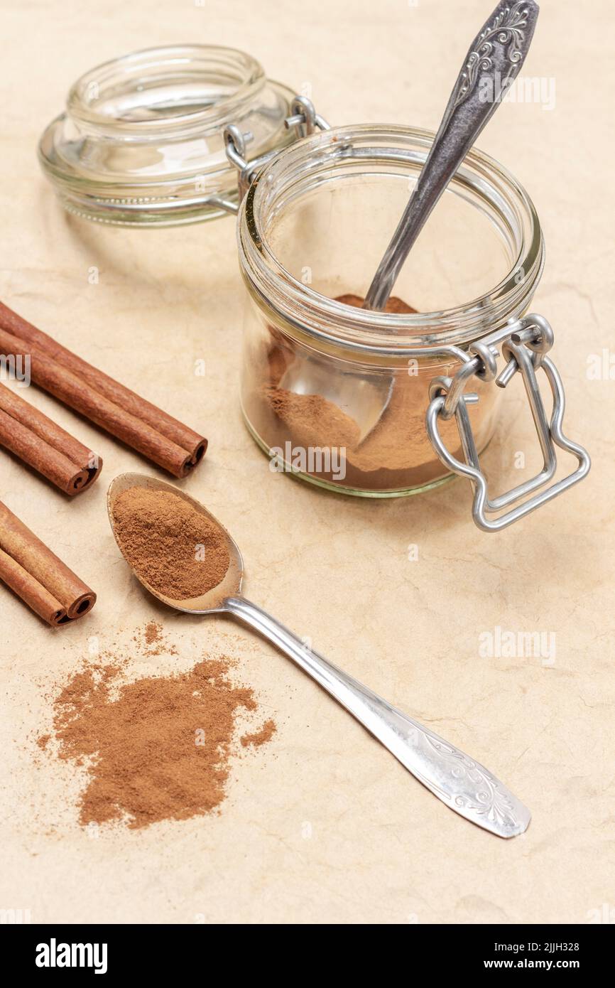 Ground cinnamon in metal spoon and on table. Ground cinnamon and spoon ...