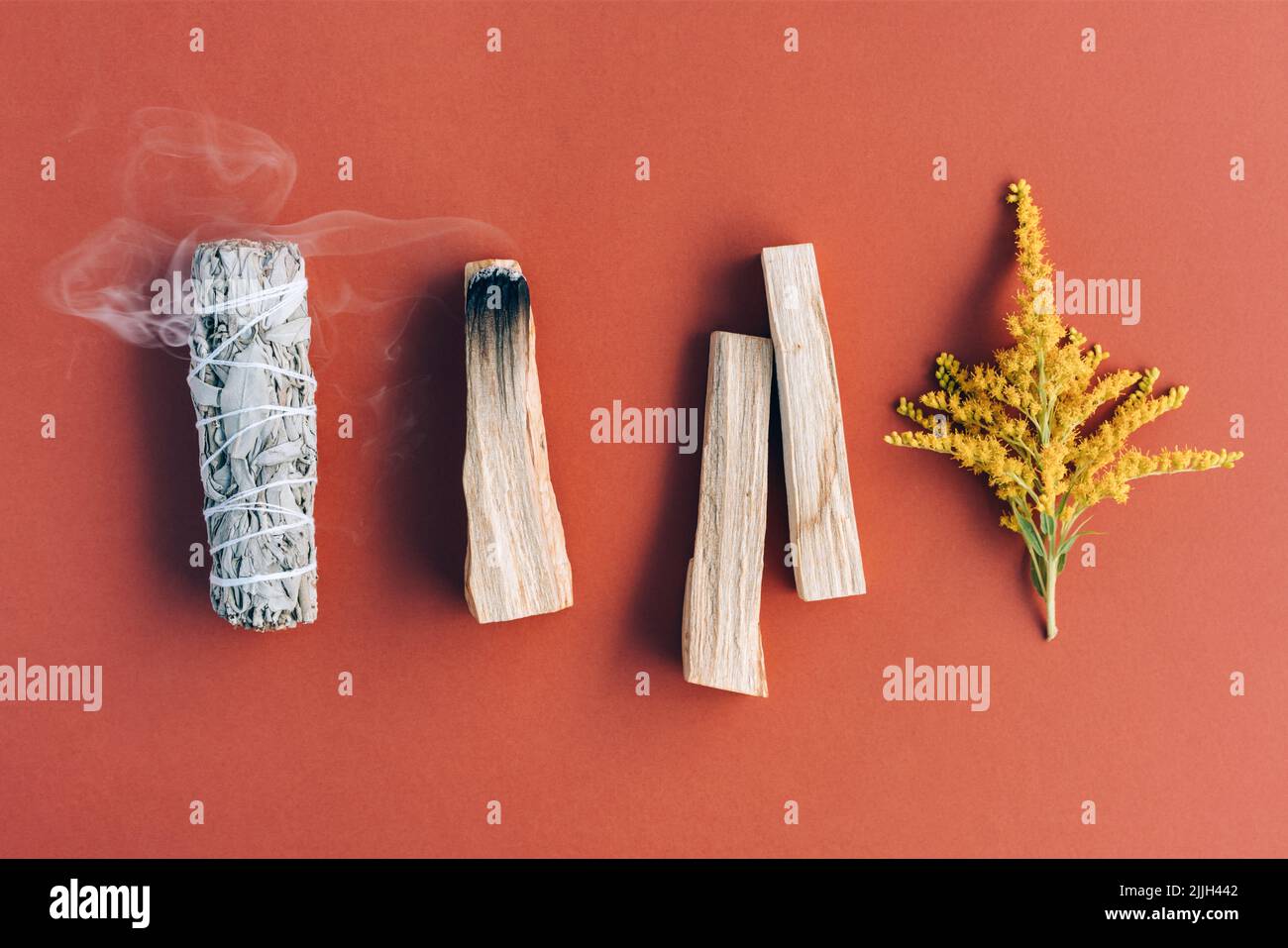 Burning incense. White sage, palo santo sticks and fragrant herbs in a ...