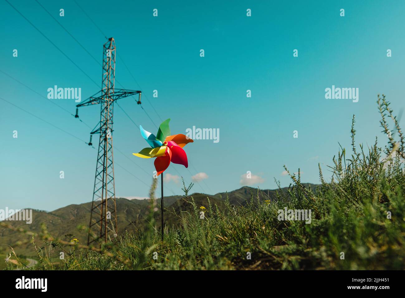 Green energy concept, pinwheel and power line on natural background ...