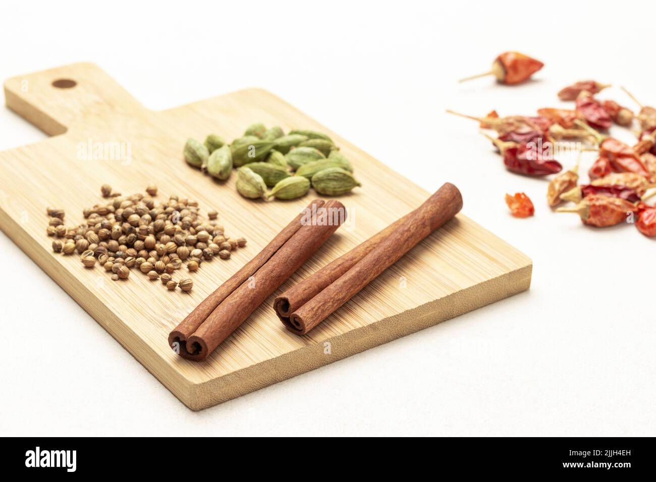 Cardamom and coriander seeds, cinnamon sticks on chalkboard. Dry pods ...