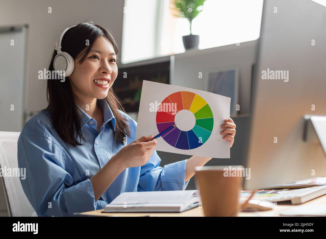 Japanese Designer Woman Showing Color Palette To Computer In Office ...