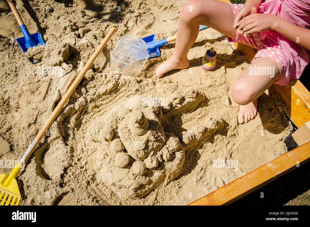 adorable blond girl having fun with sand in the playground Stock Photo ...
