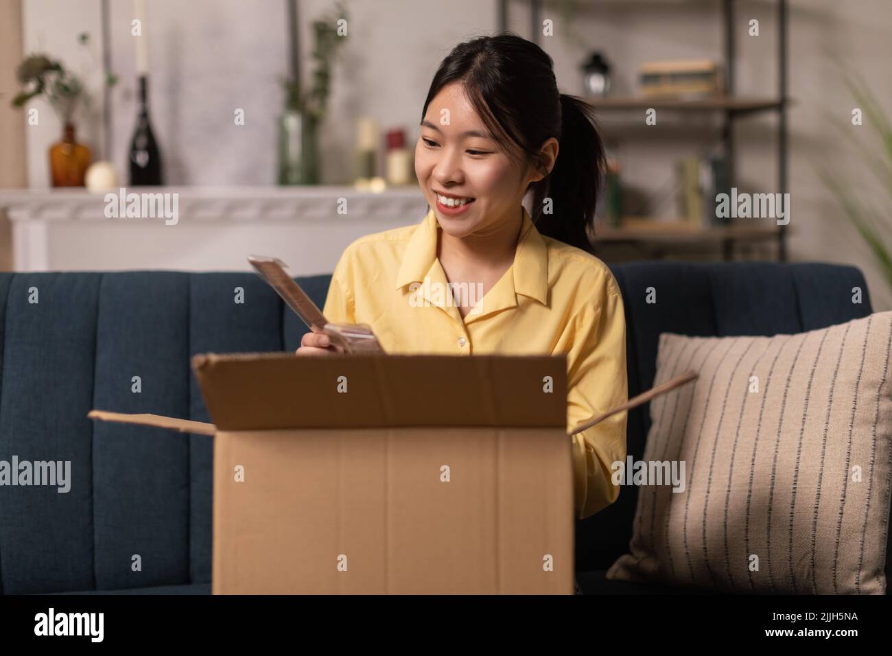 Korean Lady Unpacking Parcel With Cosmetics Products And Tools Indoors Stock Photo - Alamy