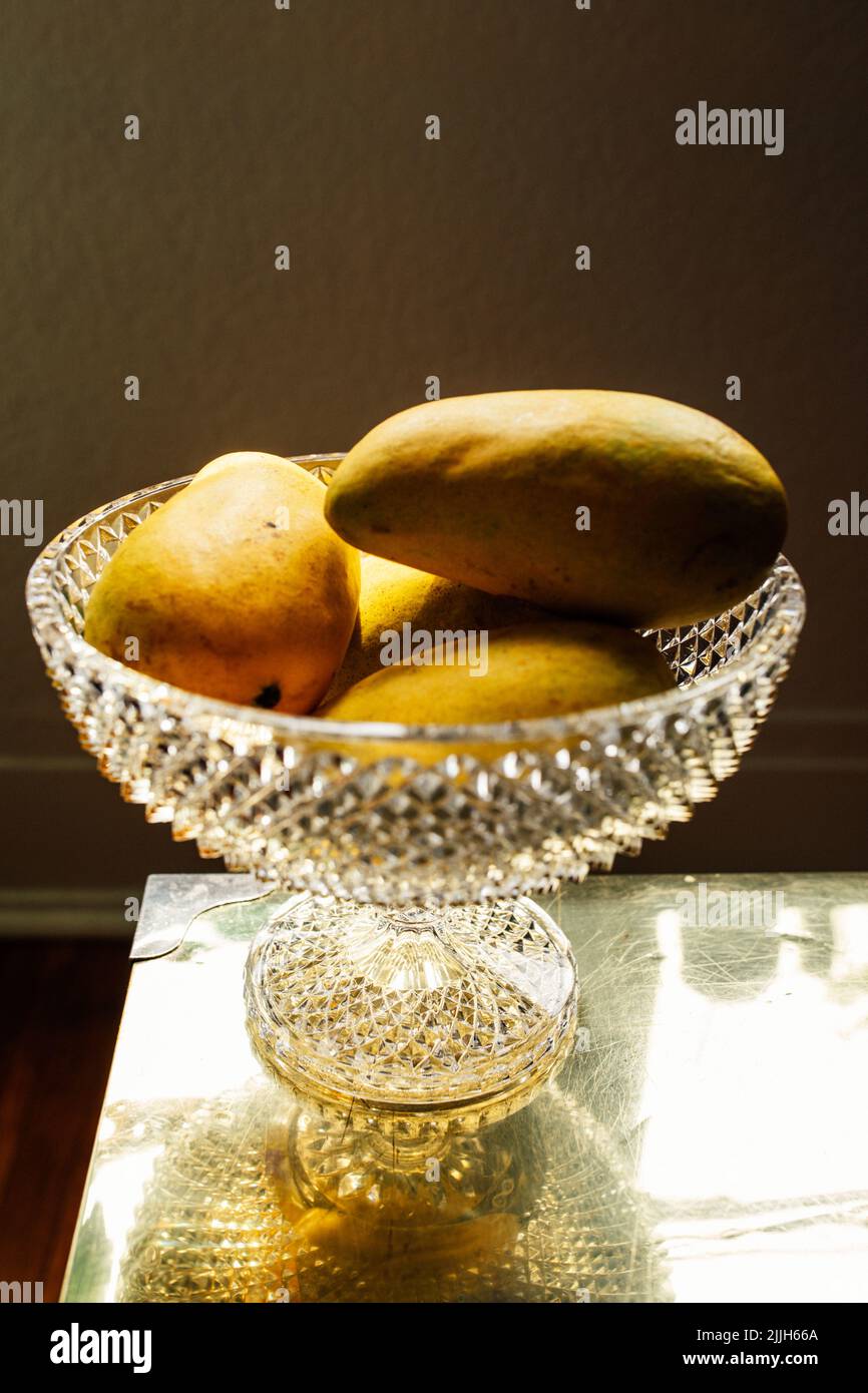 yellow champagne mango fruit in crystal bowl Stock Photo - Alamy