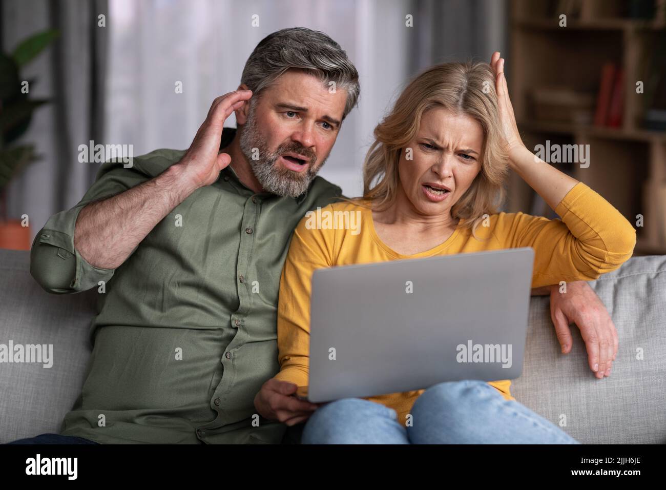 Shock Content. Frustrated Middle Aged Spouses Looking At Laptop Screen ...