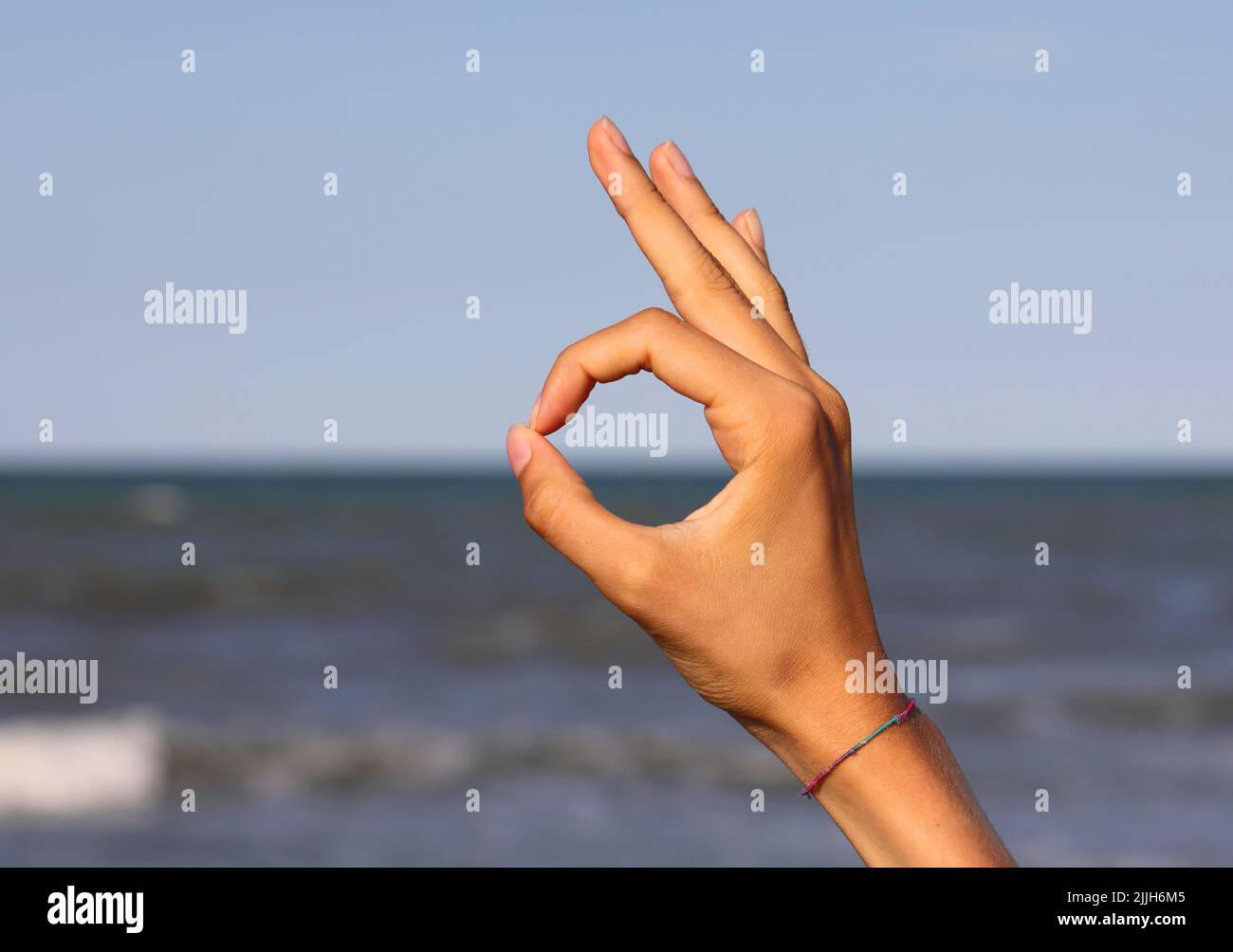 hand making OM yoga symbol with forefinger and thumb finger touching ...