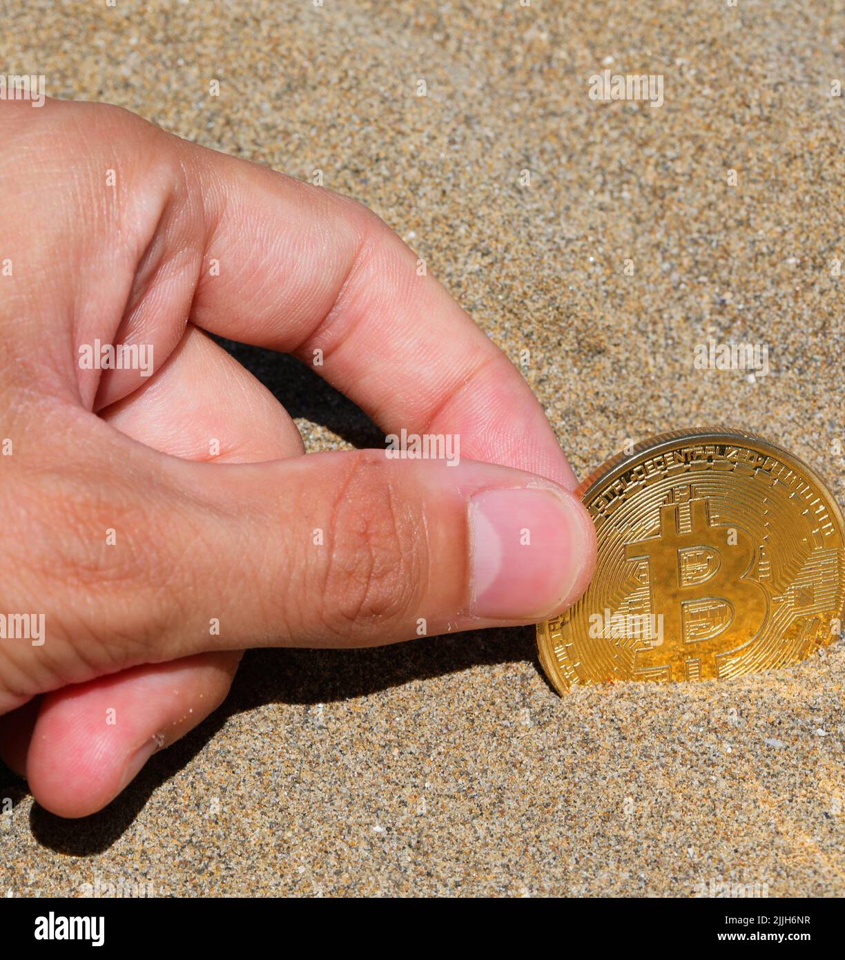 hand of man finding a golden coin with the capital letter B symbolizing ...
