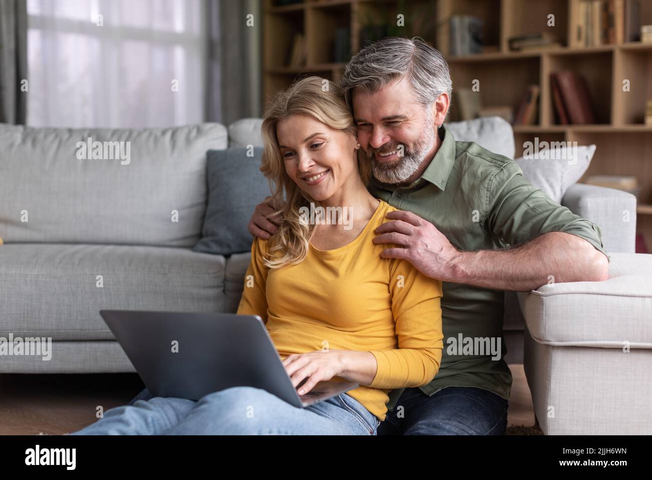 Online Communication. Happy Middle Aged Spouses Using Laptop Computer ...