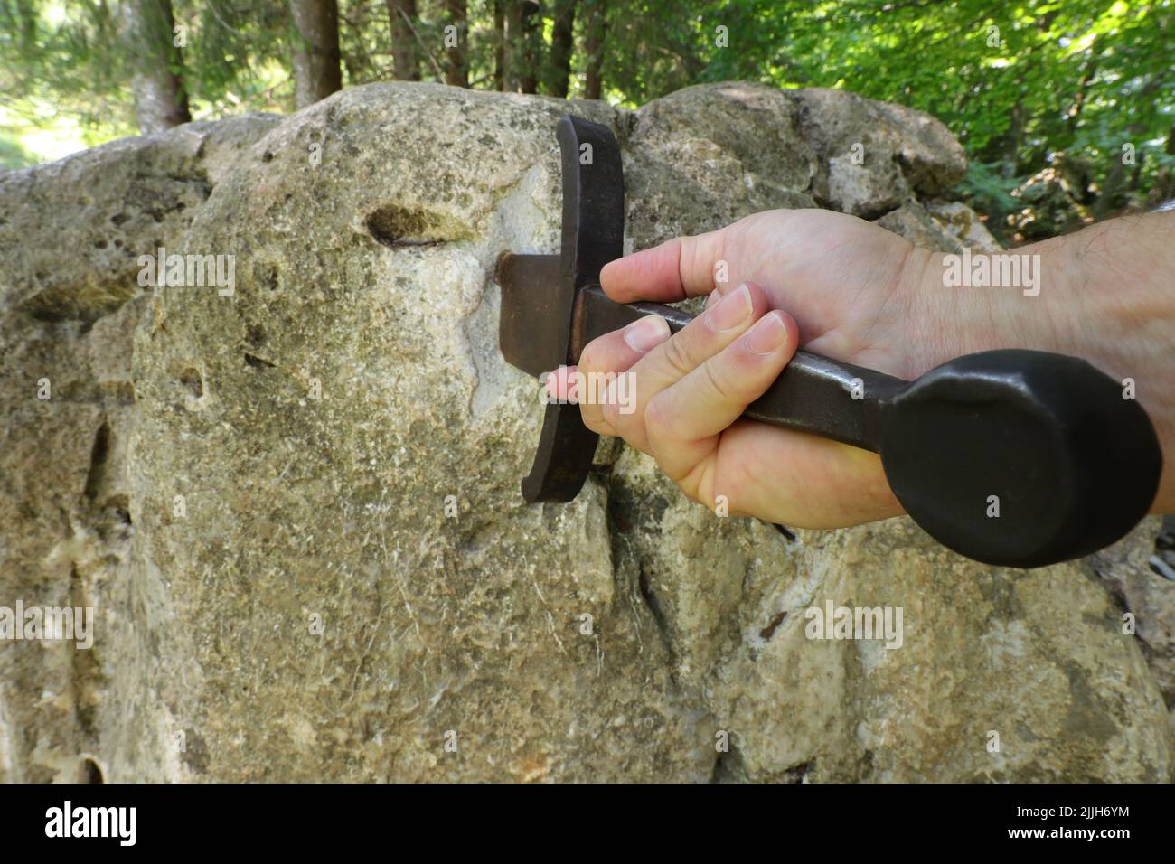 hand of knight and sword in the stone as in the legend of King Arthur ...