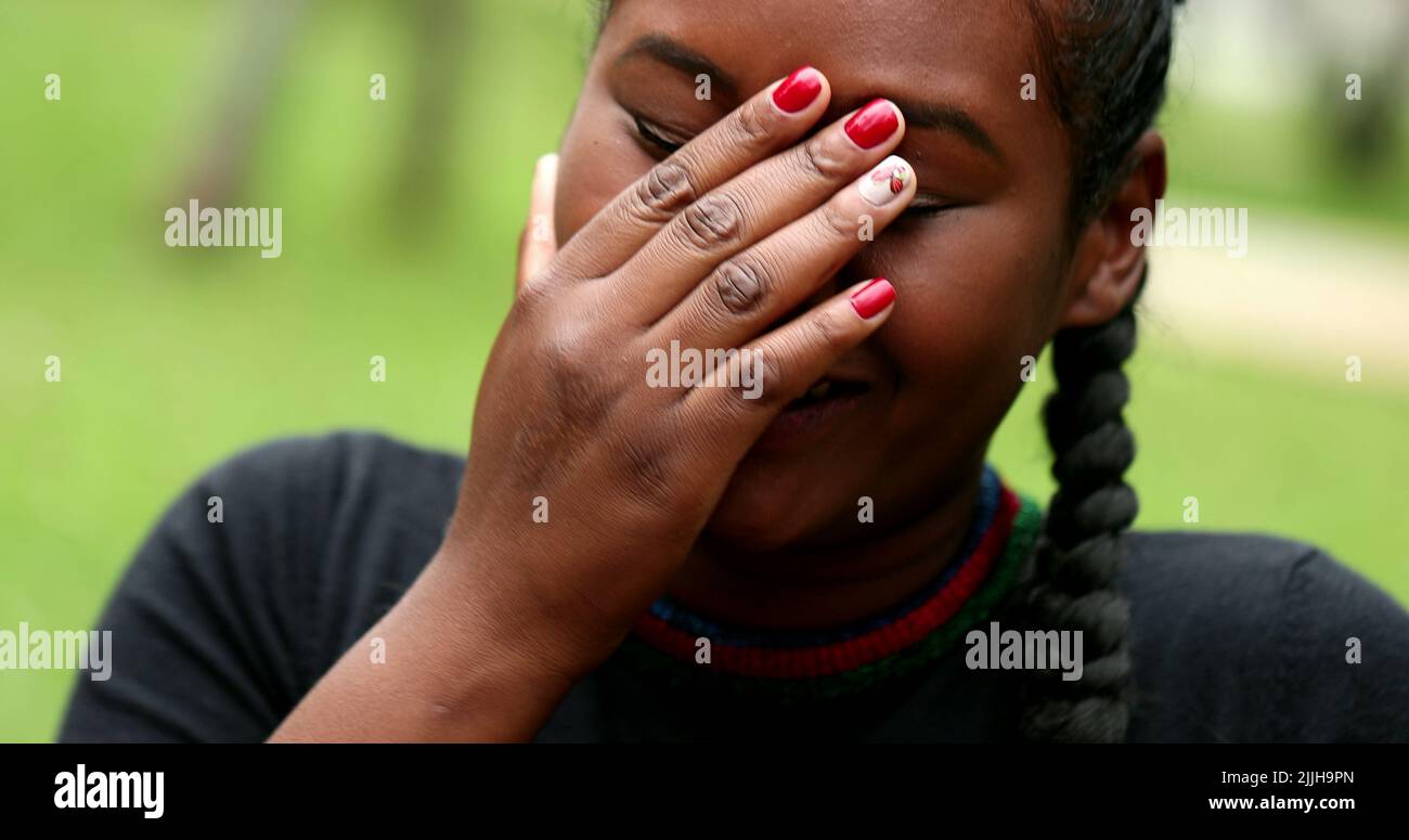 Black girl laughing covering face with hand. real life laugh Stock ...
