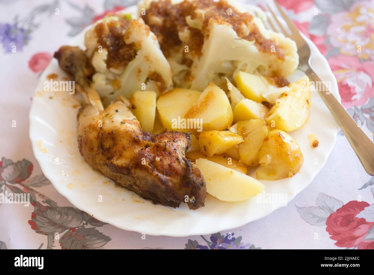 Roasted chicken legs with cauliflower and potatoes Stock Photo - Alamy