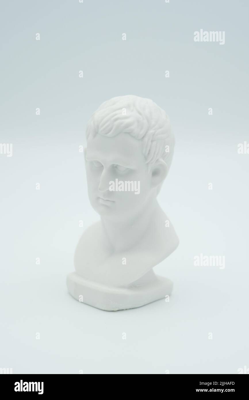 A vertical closeup shot of a miniature roman style male bust Stock ...