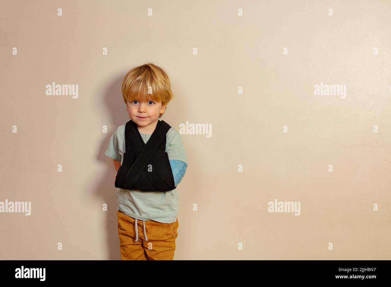 Calm young boy with broken hand in cast after accident Stock Photo - Alamy