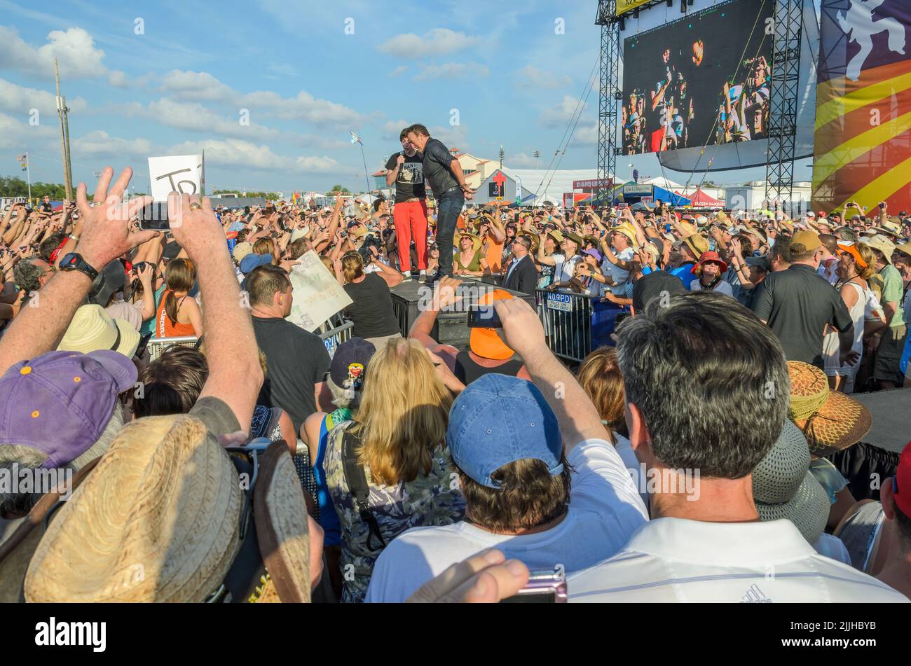 Bruce Springsteen performs with young male fan amidst the crowd at the ...
