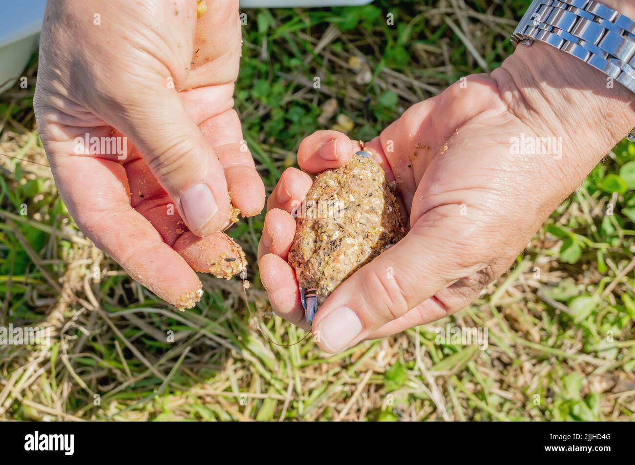 Fill the feeder with your hands for catching carp and other types of ...