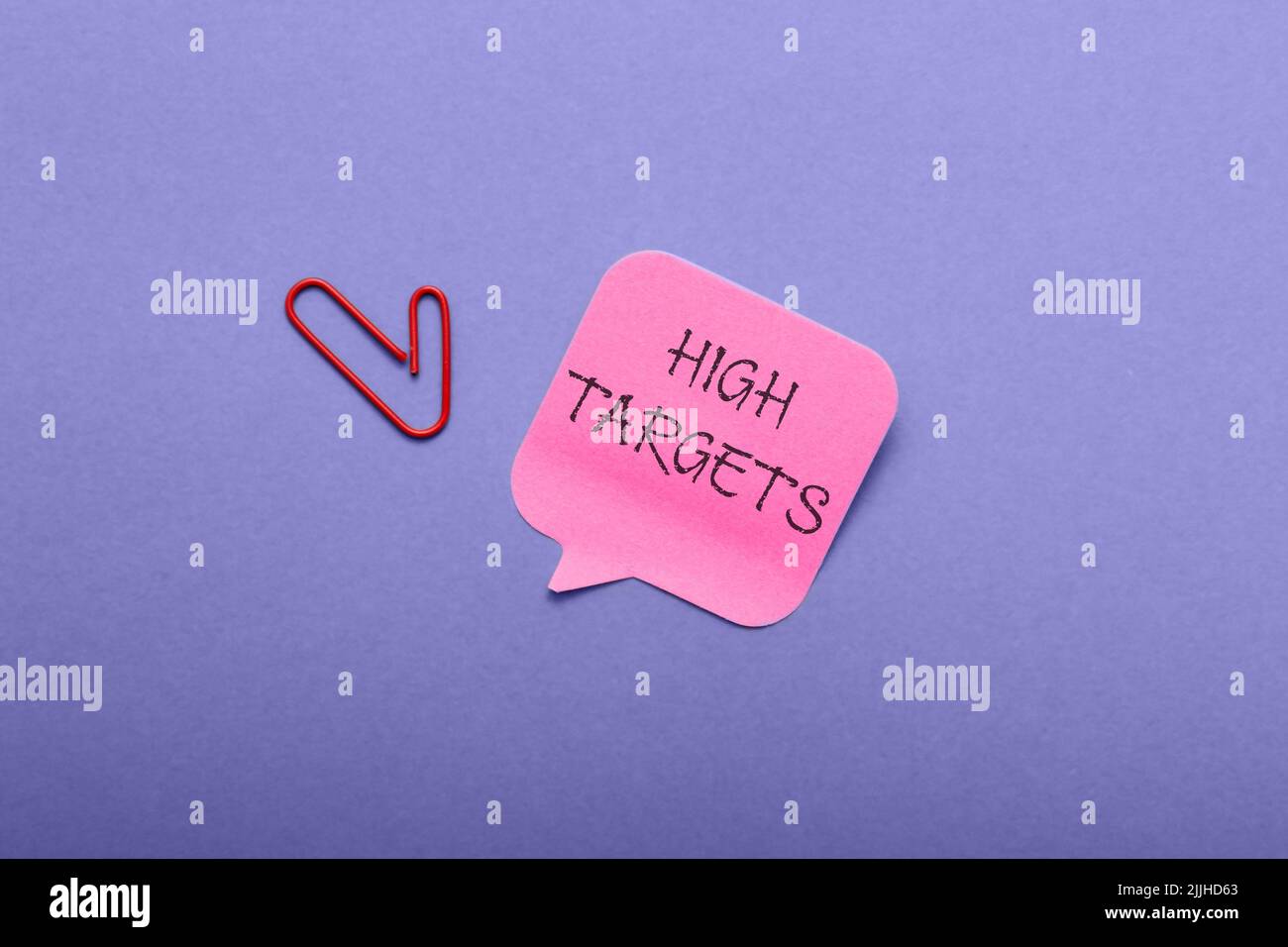 Sticker with words High Targets and paper clip on purple background ...
