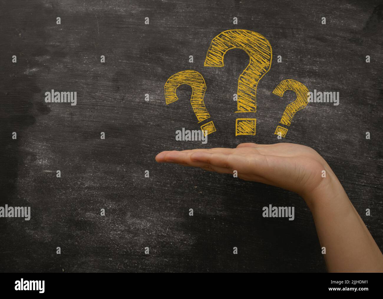 Palm with yellow question marks near blackboard closeup Stock Photo - Alamy