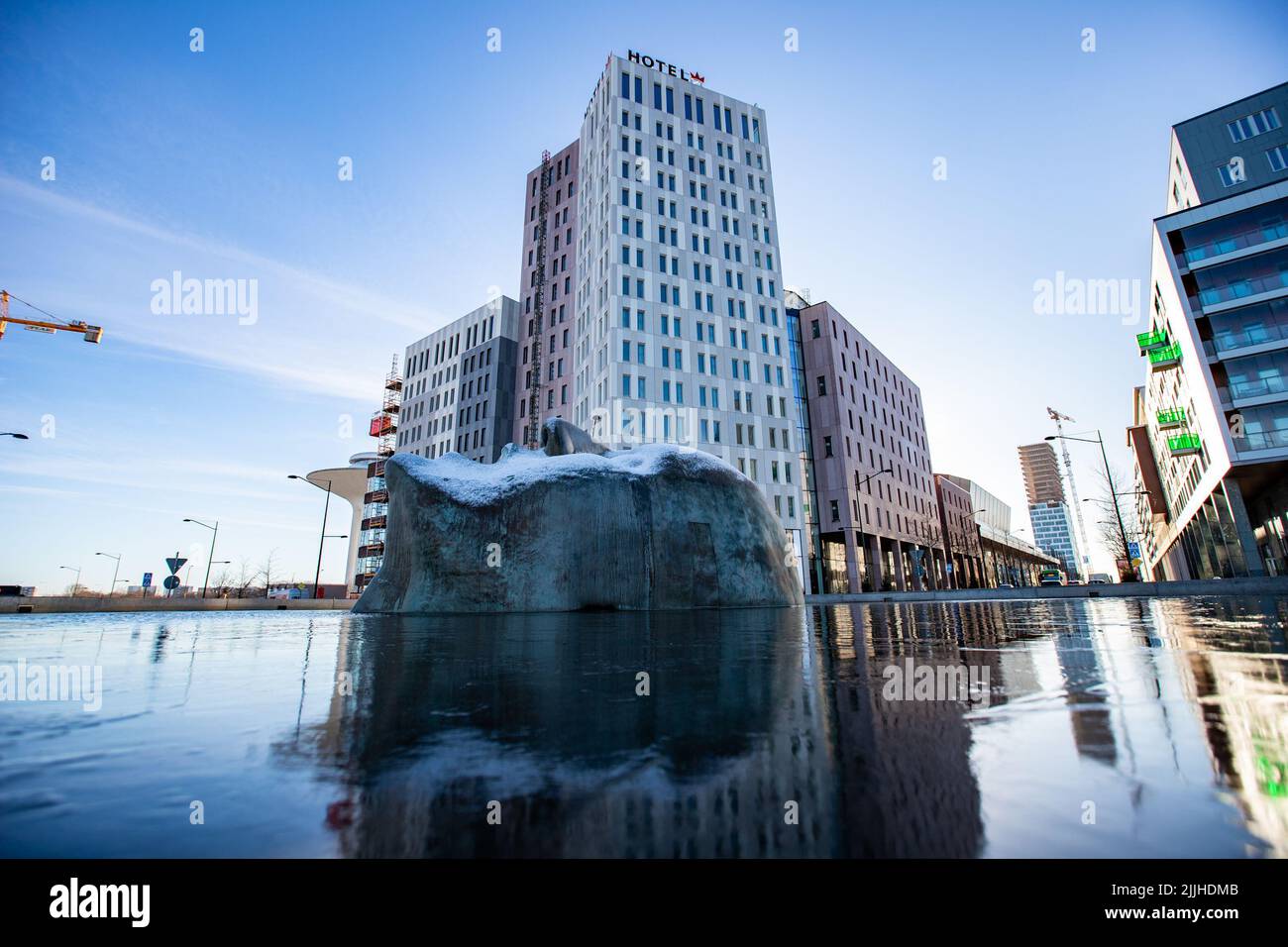 A view of the Malmo Arena Hotel with a fountain and artwork in front of ...