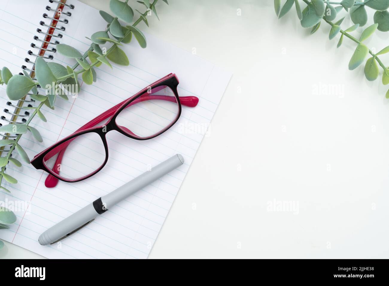 A top view of a tidy workspace with a notebook, a pen and glasses Stock ...