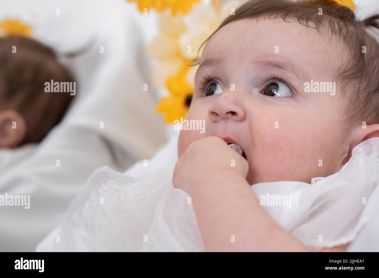 close-up detail of the face of a beautiful latin baby girl lying in her ...