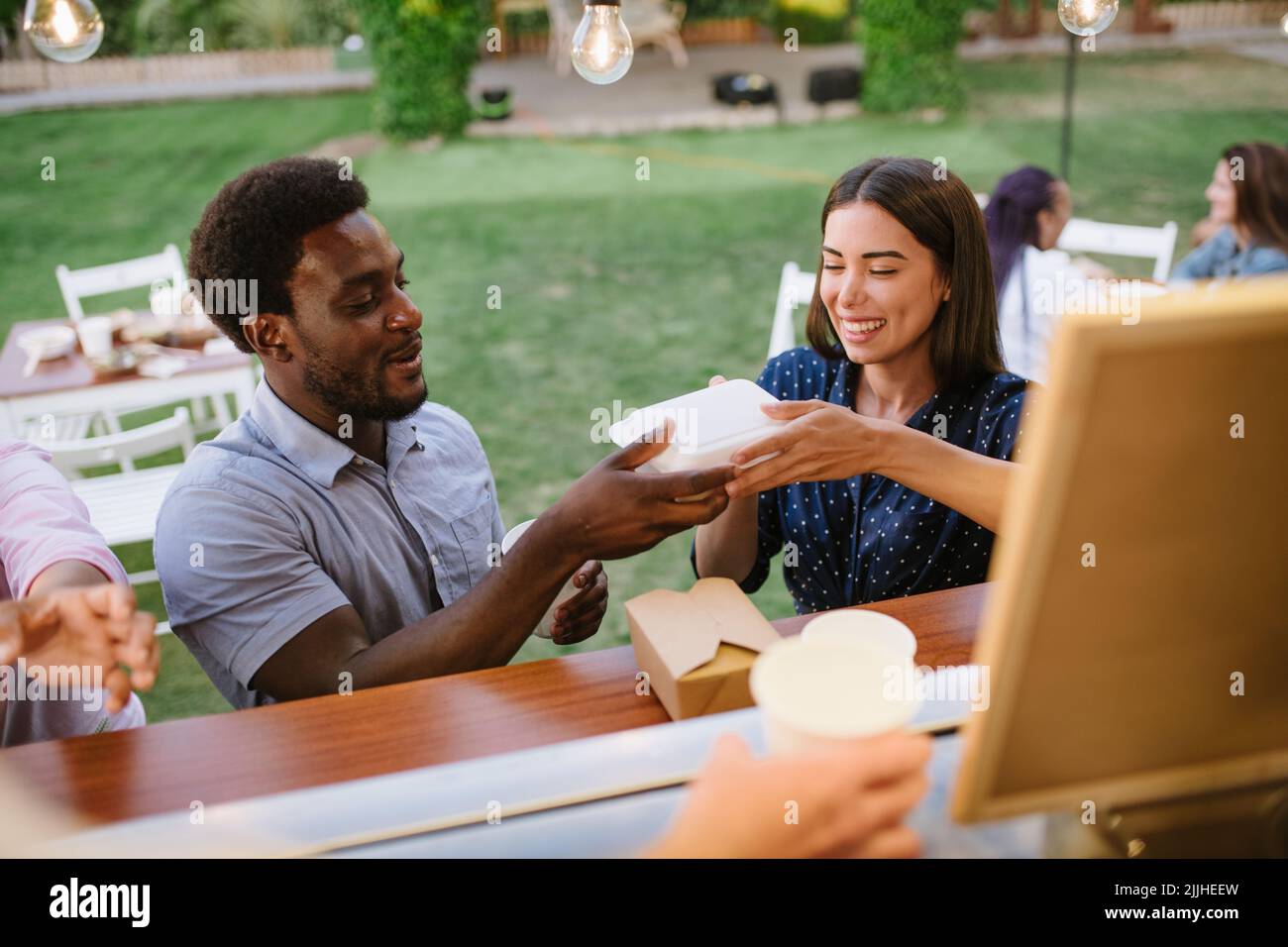 Diverse customers receiving orders outside food truck Stock Photo - Alamy