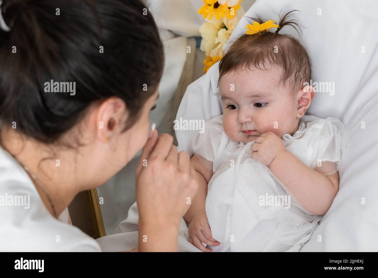 latina mother caressing and pampering her beautiful baby girl. woman ...
