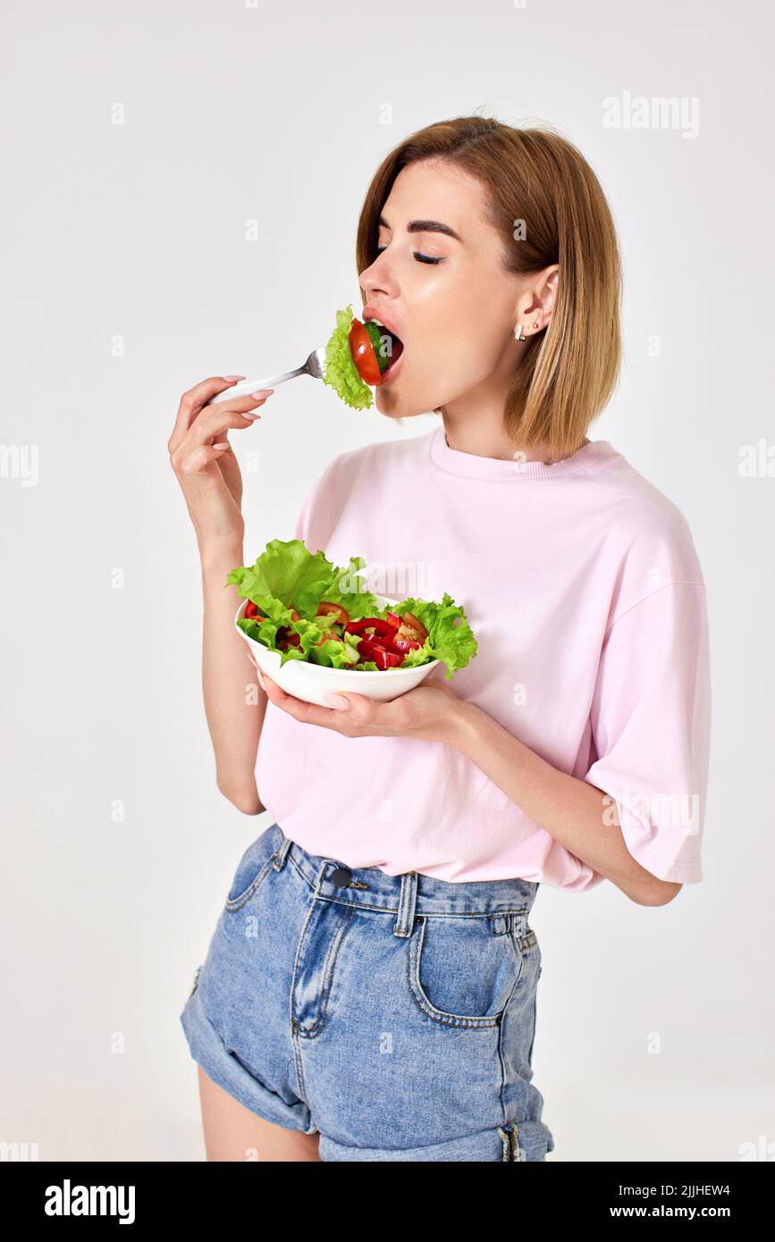 beautiful woman eating fresh vegetable salad on white background Stock ...