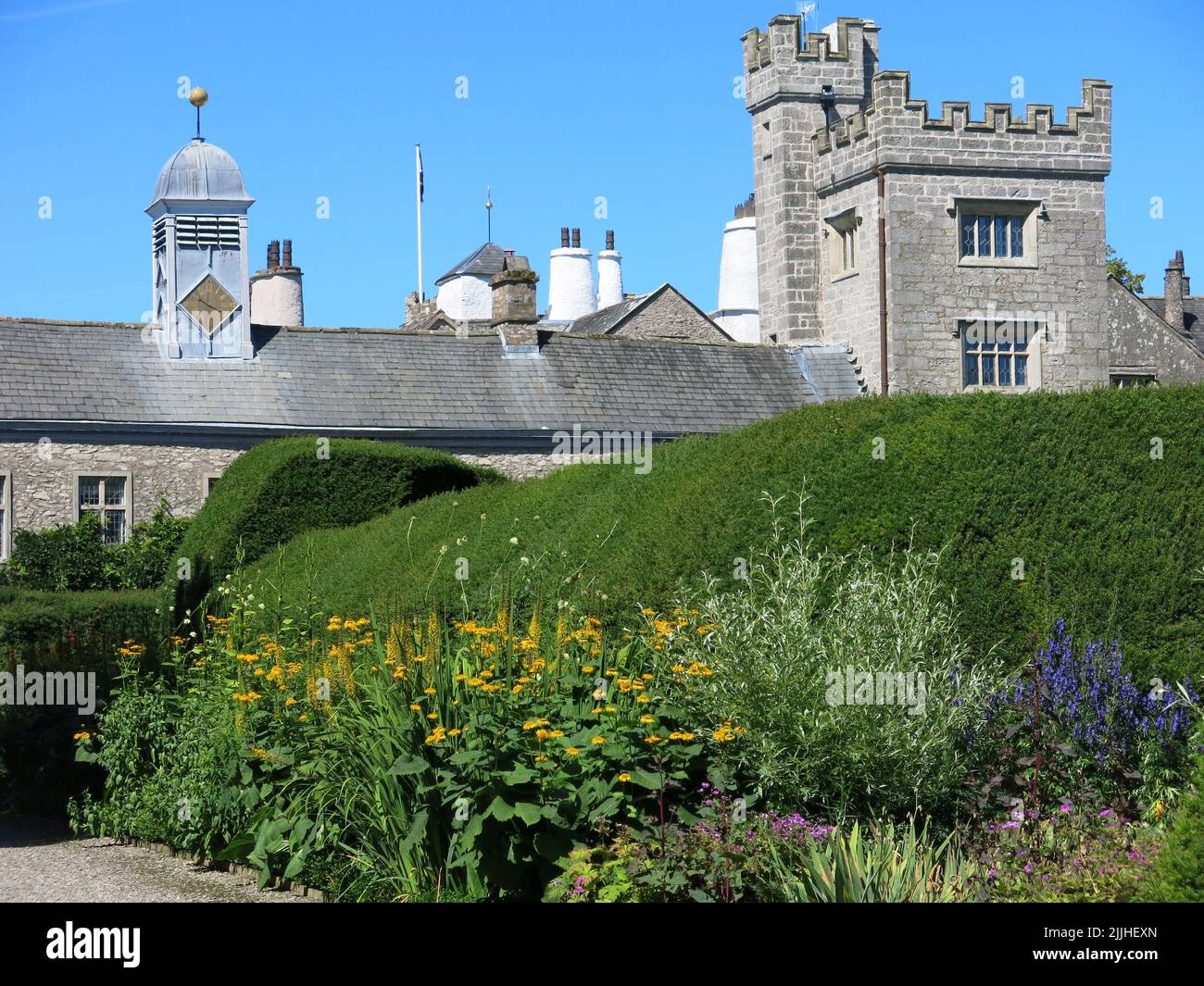 View of the manor house behind a clipped hedge at Levens Hall in ...