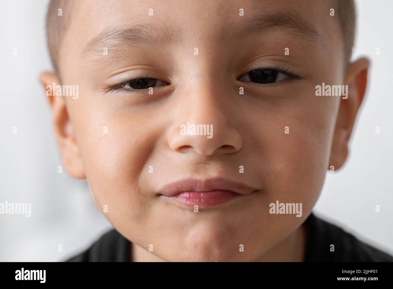 close-up of a latin child making a face of disgust and boredom. little ...
