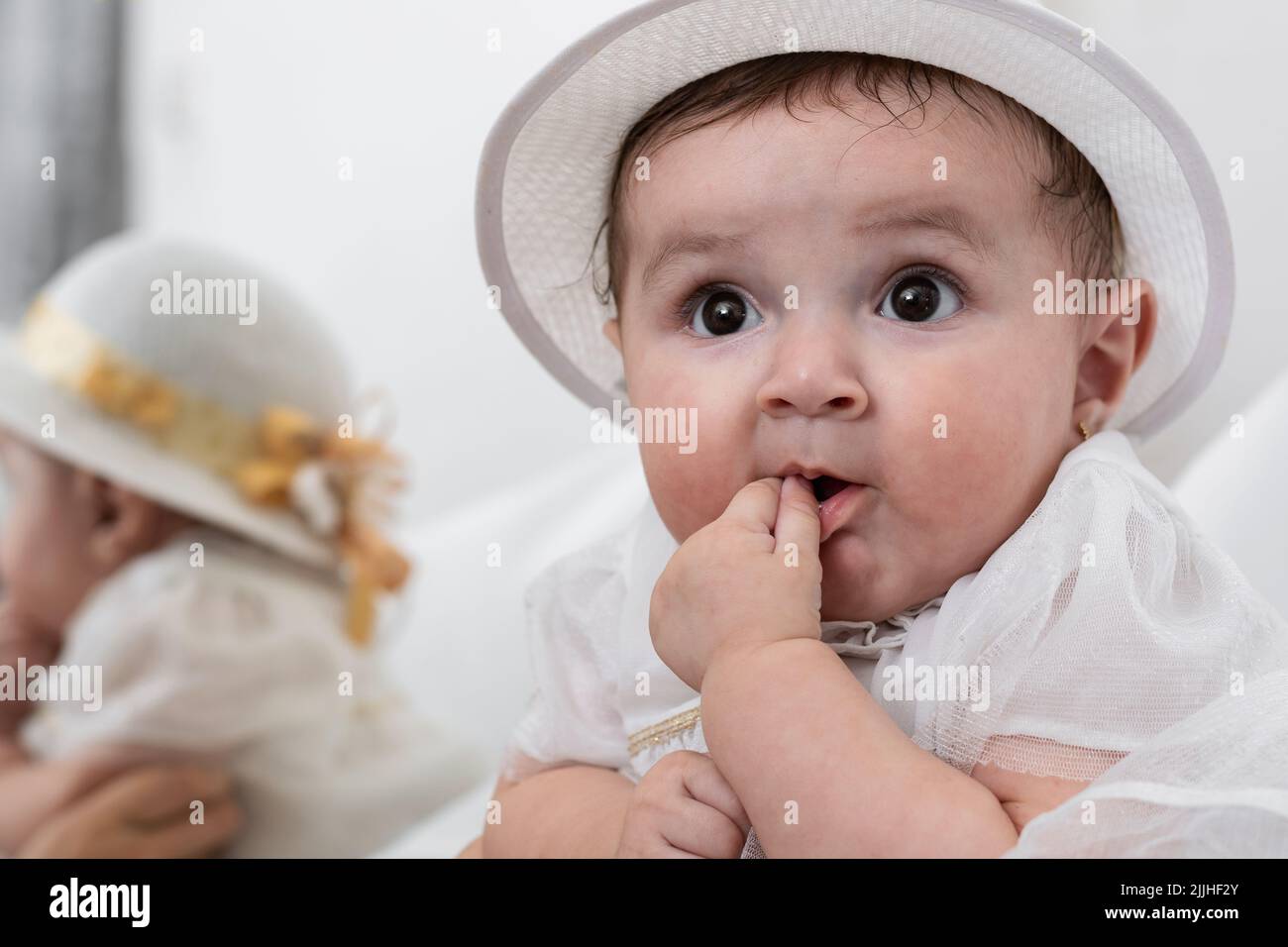 close-up of a beautiful white-skinned latina baby girl with a white ...
