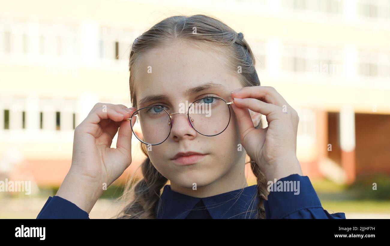 A teenage girl wearing glasses in front of a school Stock Photo - Alamy