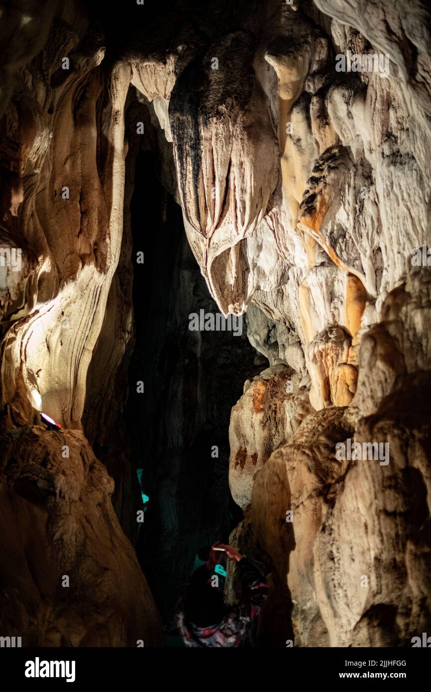 A vertical view of mineral stalactites hanging from the ceiling and ...
