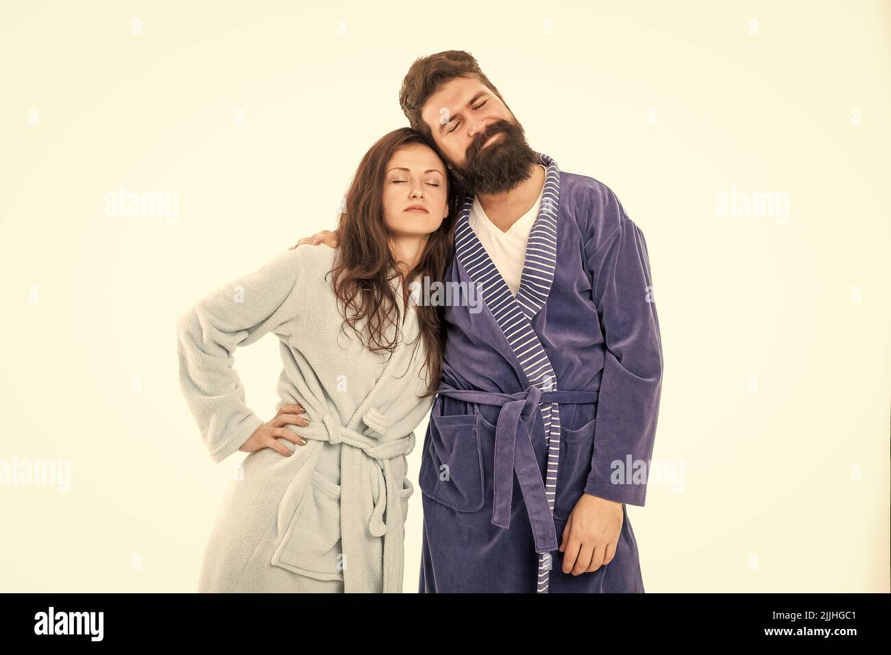 Tired couple of man and woman stand sleeping in cozy robes isolated on ...