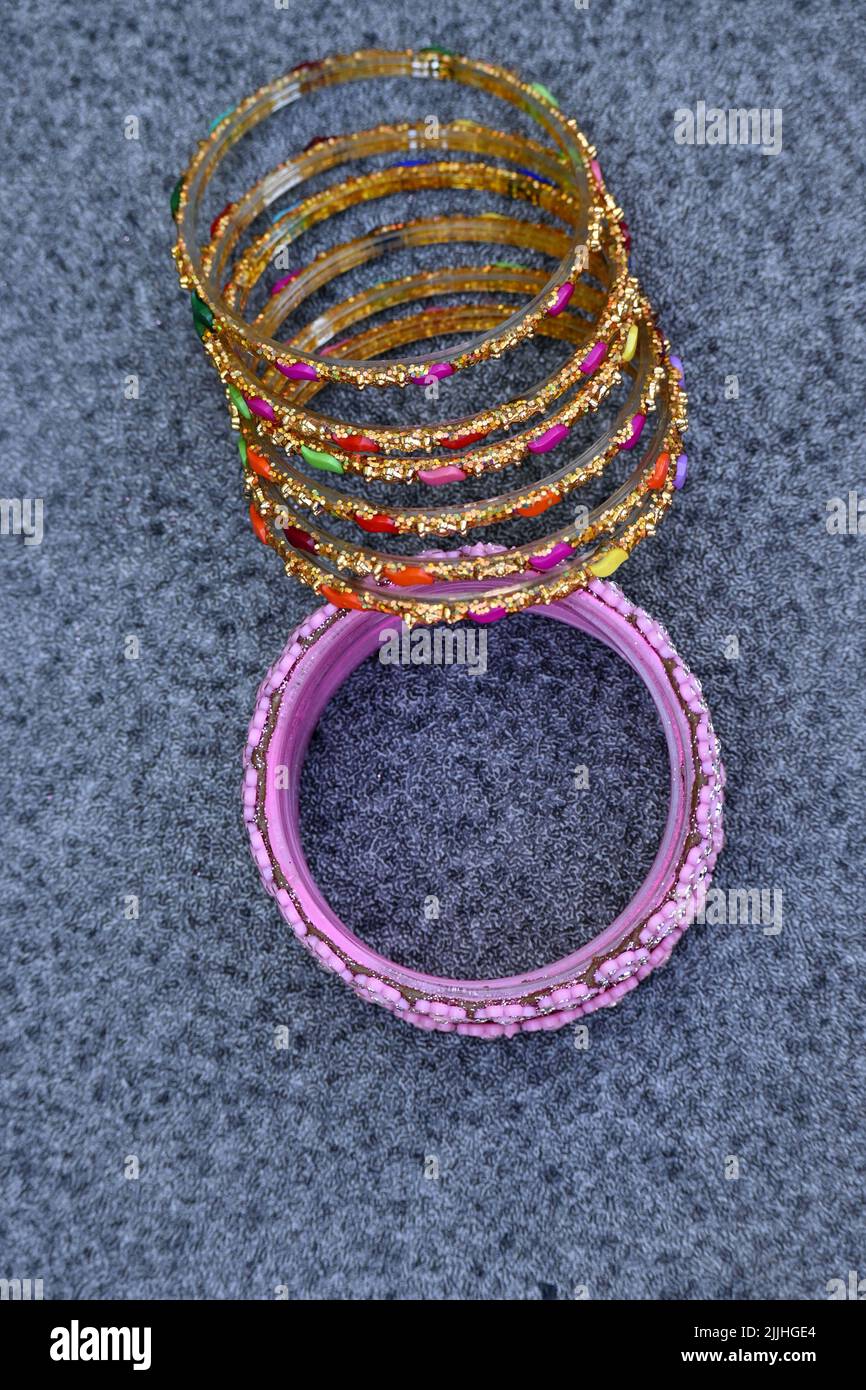 A vertical closeup of colorful bangles on the grey background Stock ...