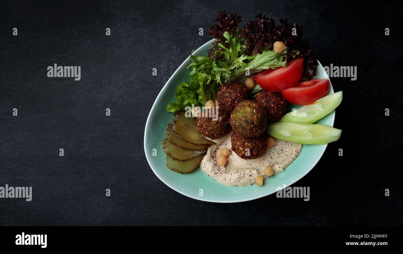 Arabian meal, hummus and falafel with fresh vegetables. on gray ...