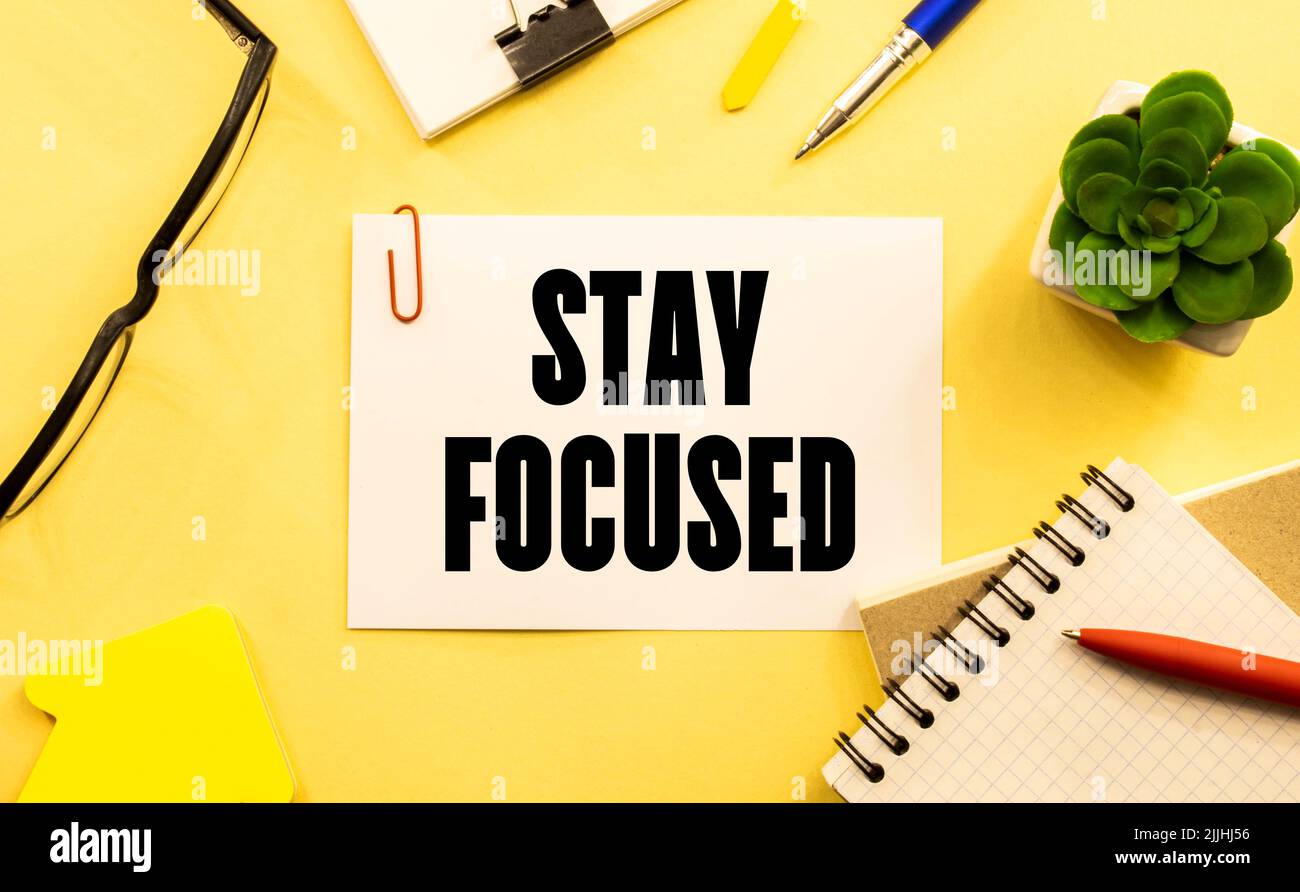 STAY FOCUSED man hand notebook and other office equipment such as ...