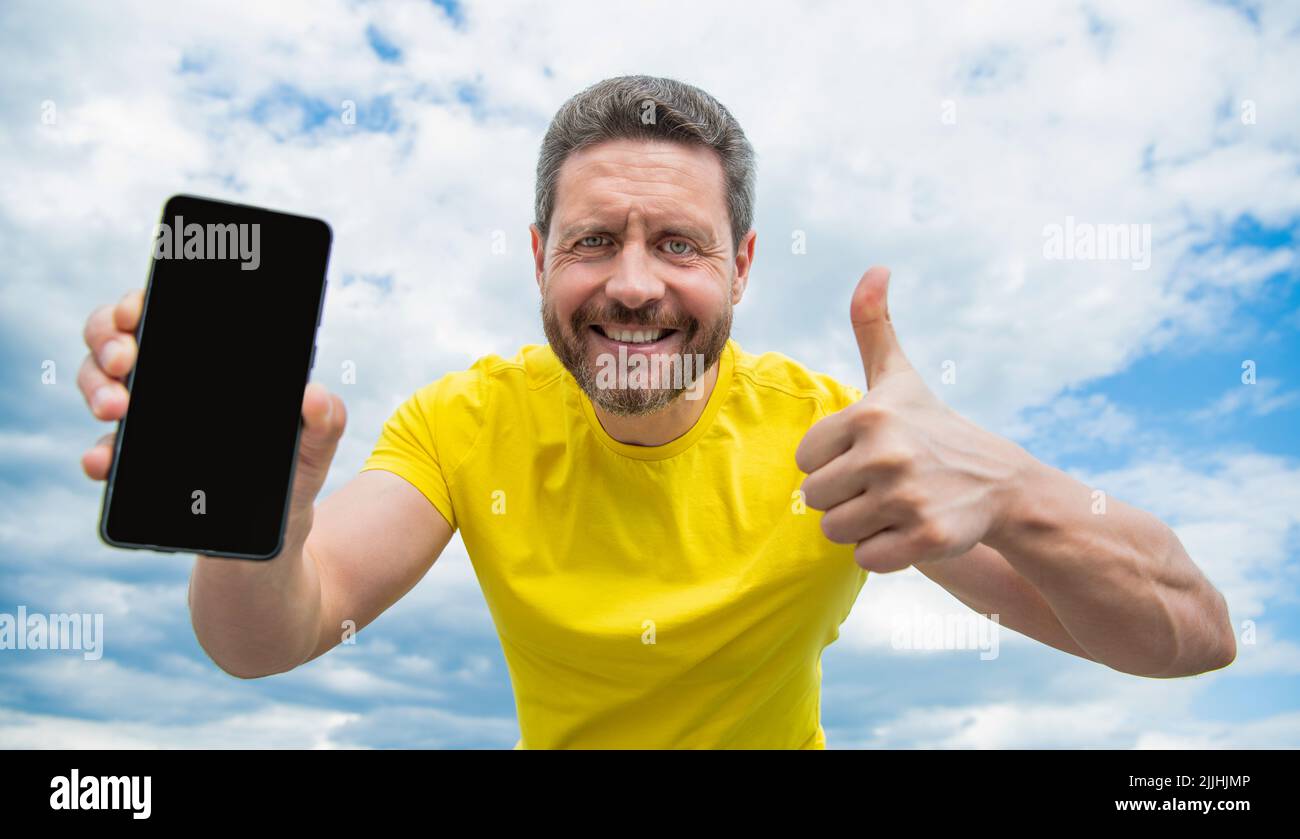 glad man presenting screen of smartphone with copy space Stock Photo ...