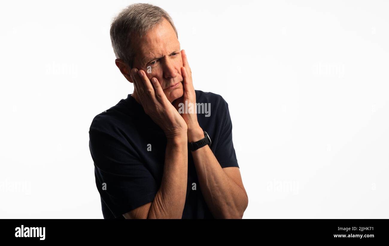 Older man stressed, hands held to his face. Suggested mental health ...
