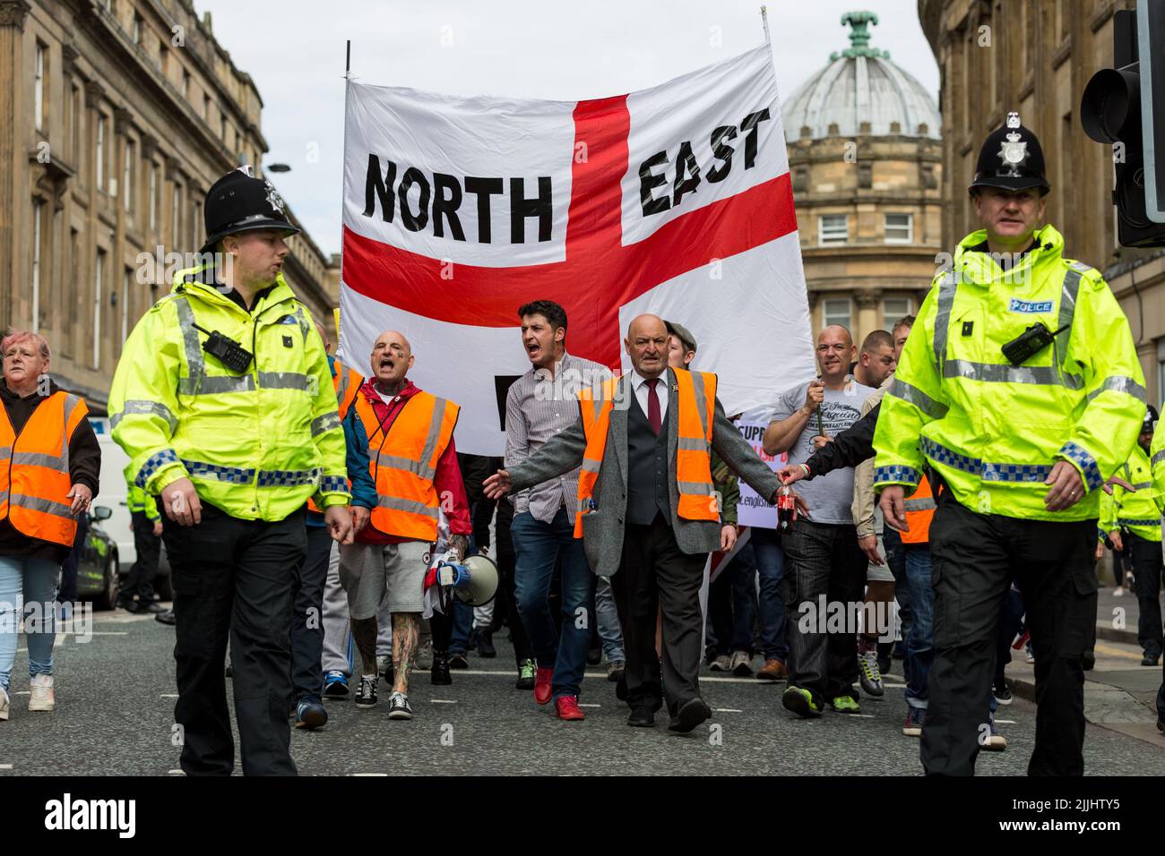 A group of people participating in the EDL marches and policemen ...