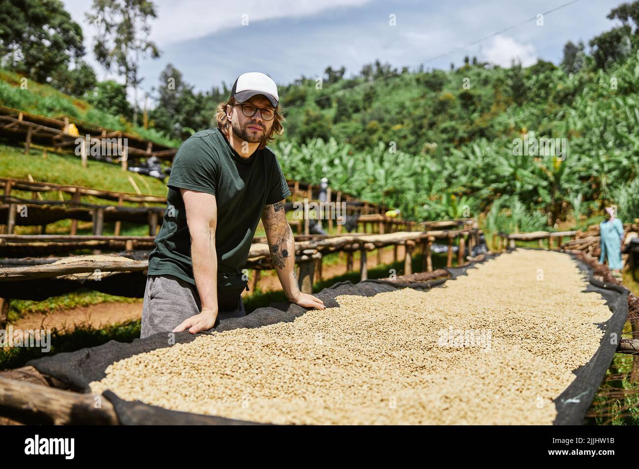 Guy in cap standing near coffee washing station Stock Photo - Alamy