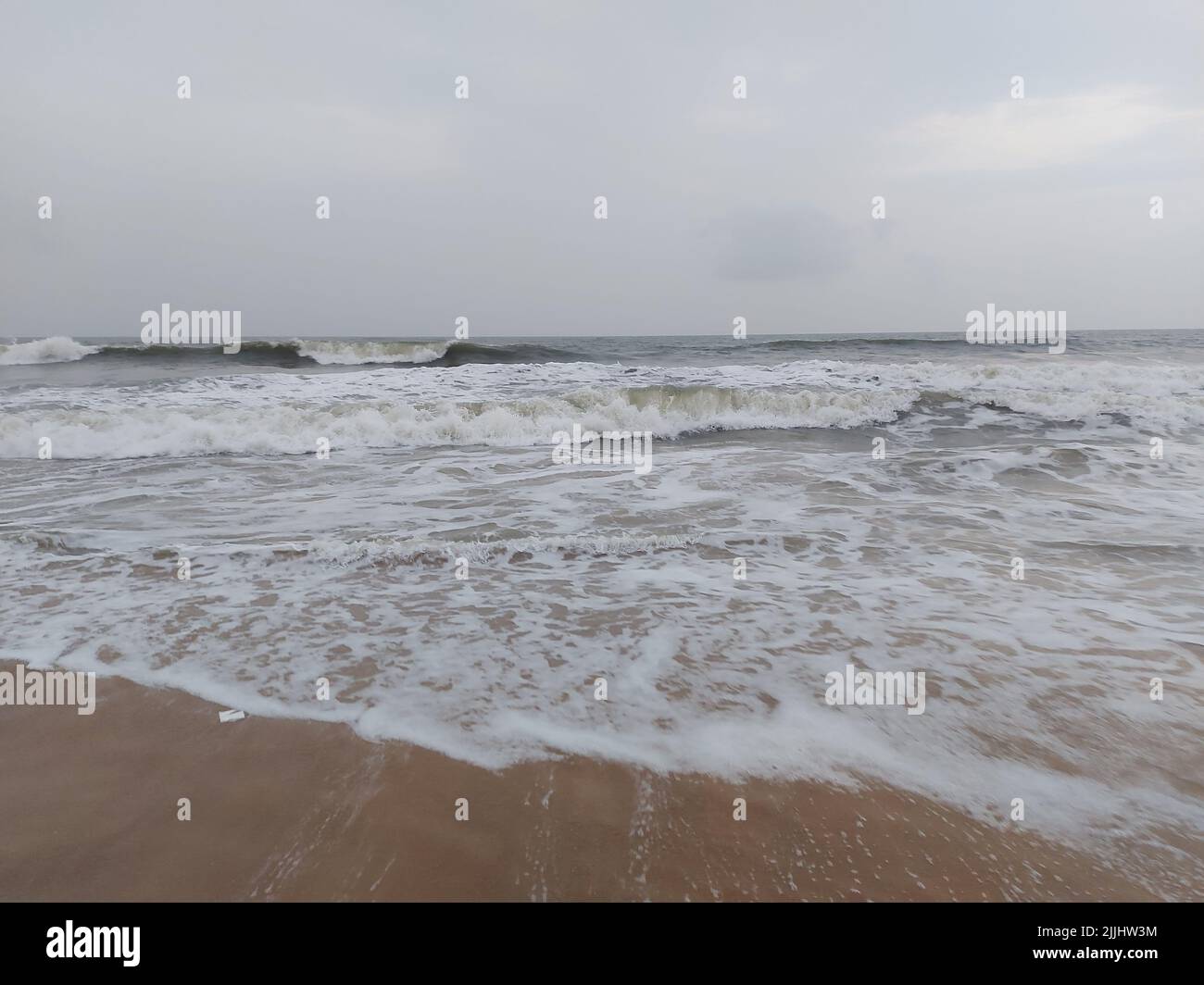 The foam and waves of the sea in Calangute beach under gray sky Stock ...