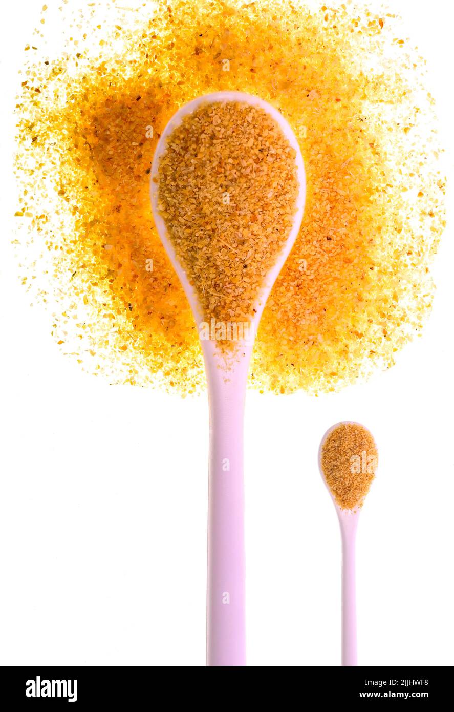 Dried granulated garlic, Allium sativum, on a white background. It is a ...