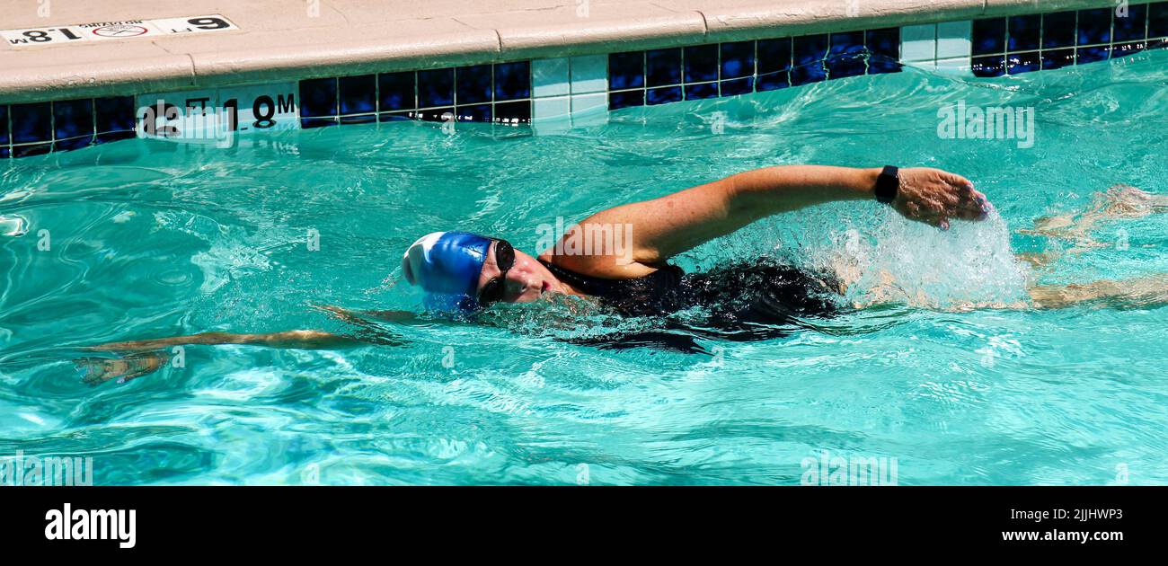 Side view of a women swimming freestyle laps in a hotel pool Stock ...