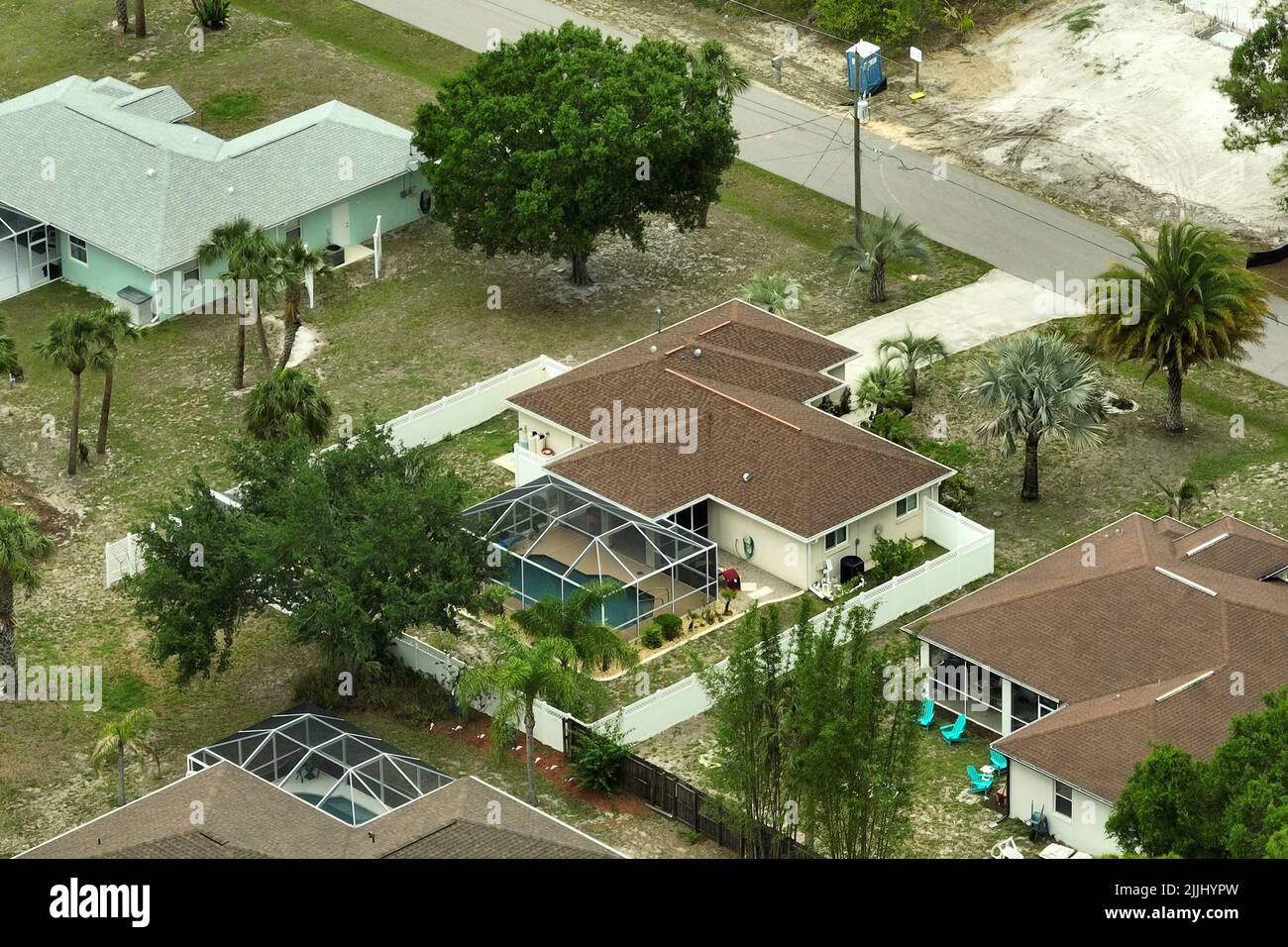 Aerial landscape view of suburban private houses between green palm ...