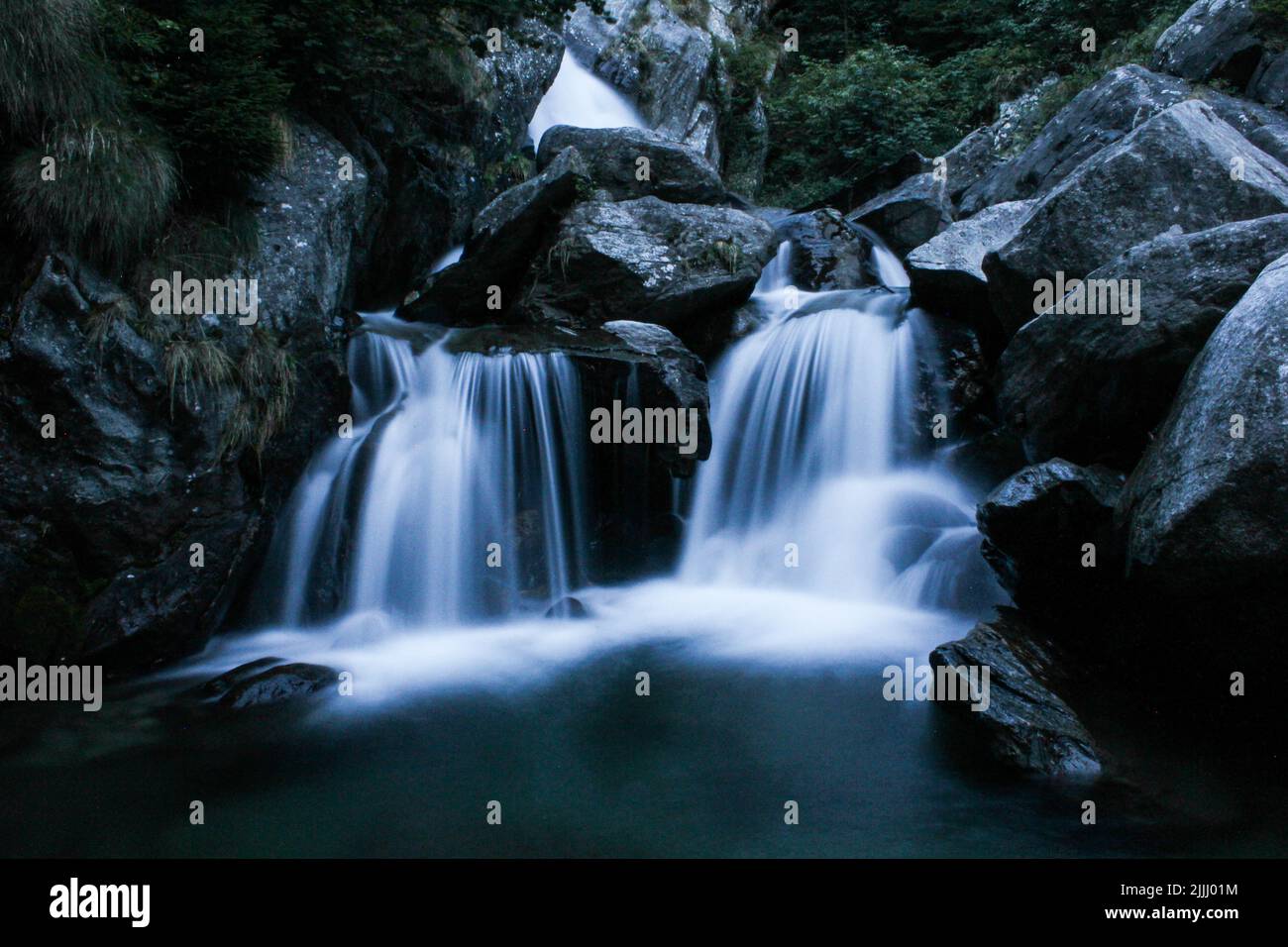 A beautiful waterfall with rocks in a forest Stock Photo - Alamy