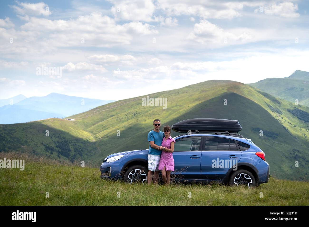 Couple standing neat off road car on mountain trail. Traveling by auto ...