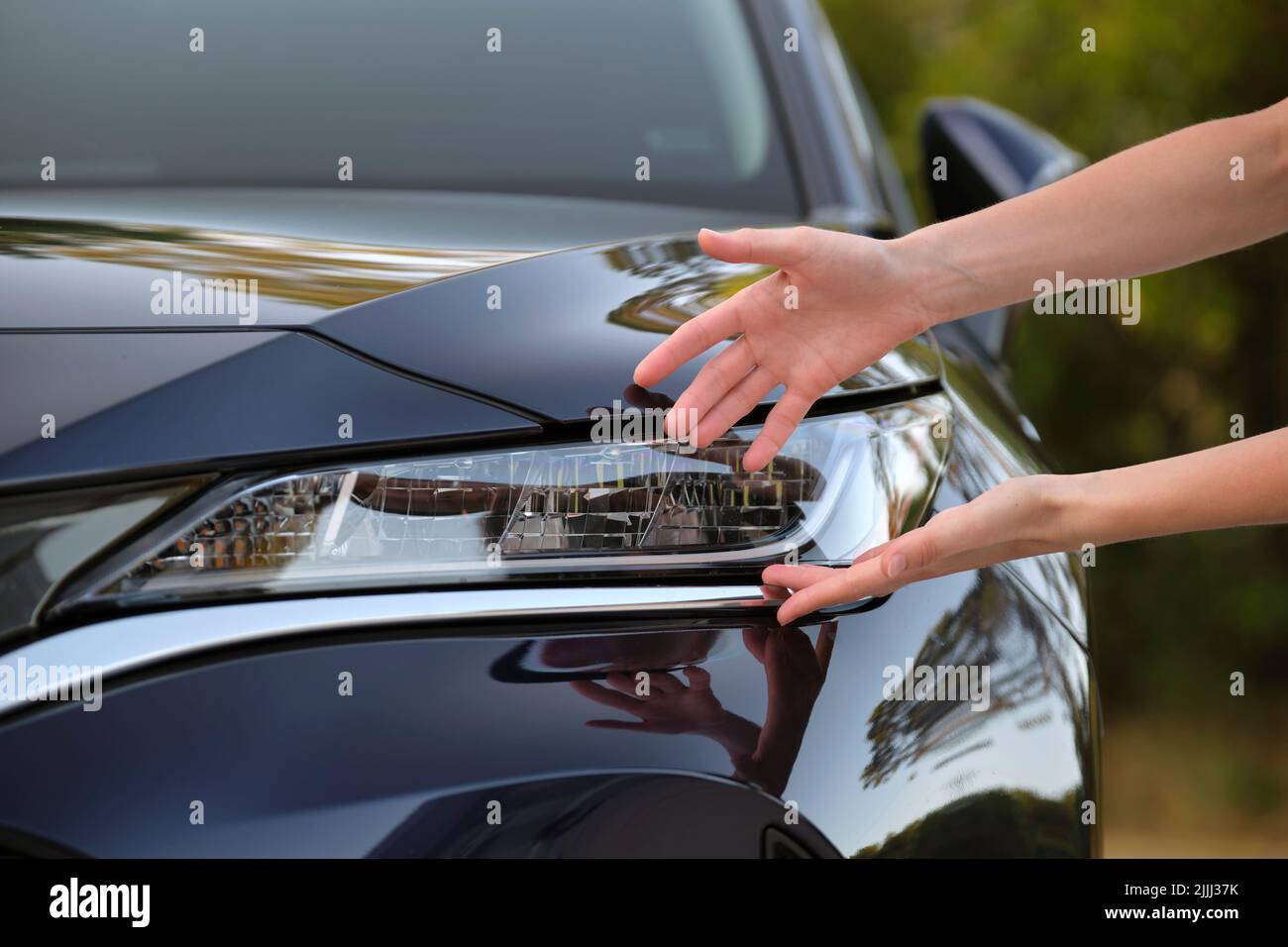 Female driver hands checking headlight of her new car. Purchase of ...